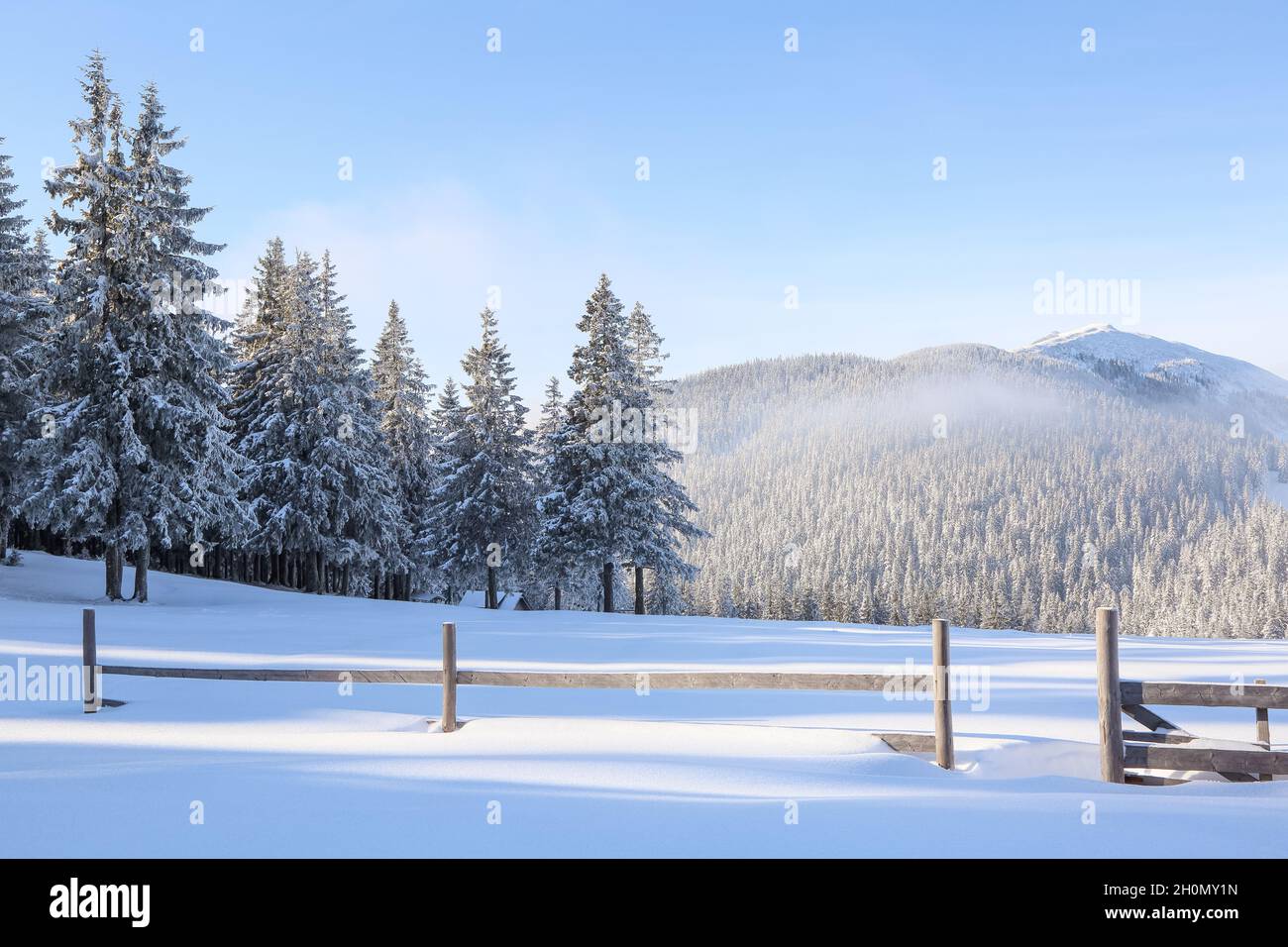 Winter scenery. Wooden fence. Beautiful landscape of high mountains ...