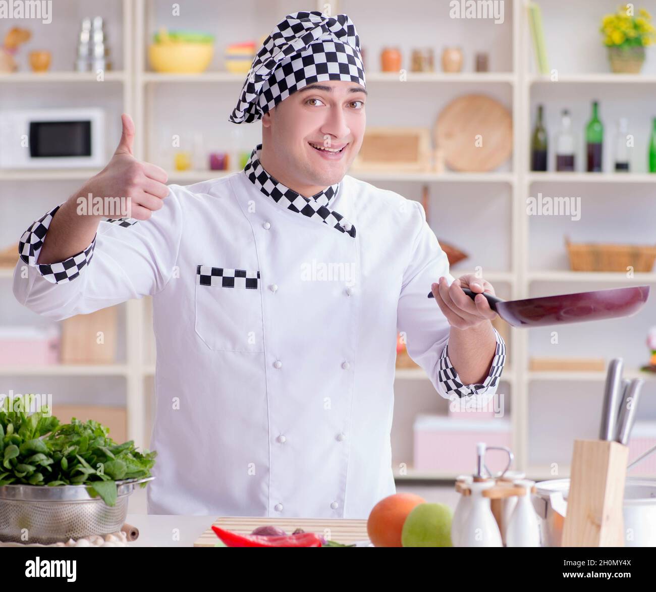 The young male cook working in the kitchen Stock Photo - Alamy