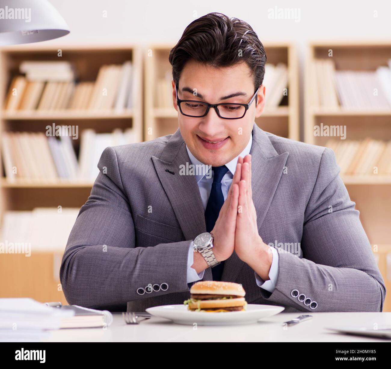 The hungry funny businessman eating junk food sandwich Stock Photo - Alamy