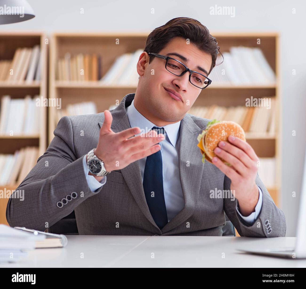 The hungry funny businessman eating junk food sandwich Stock Photo - Alamy