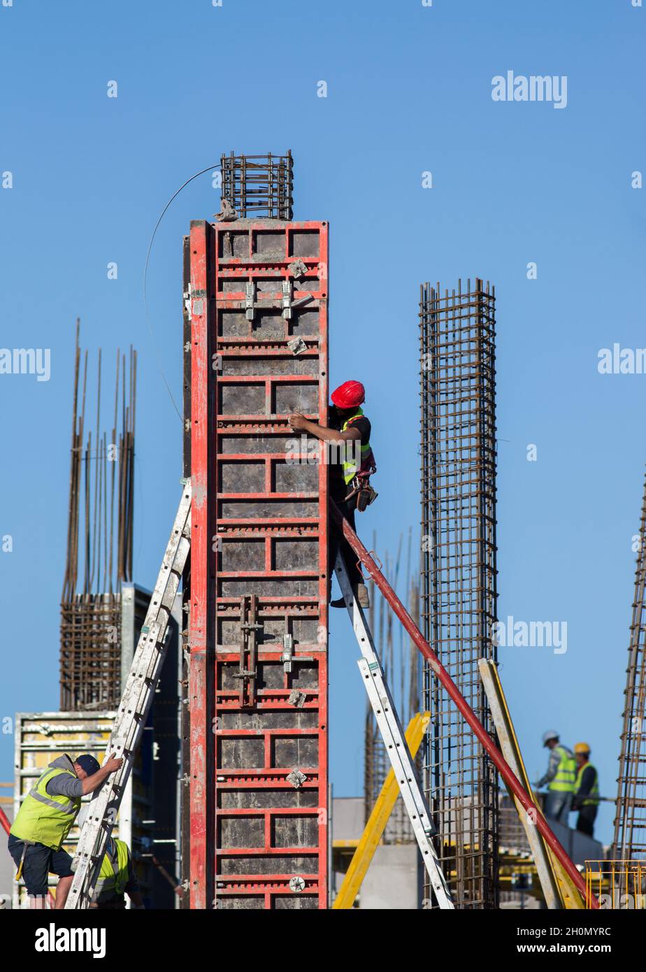Construction workers assembling formworks for concrete column at ...