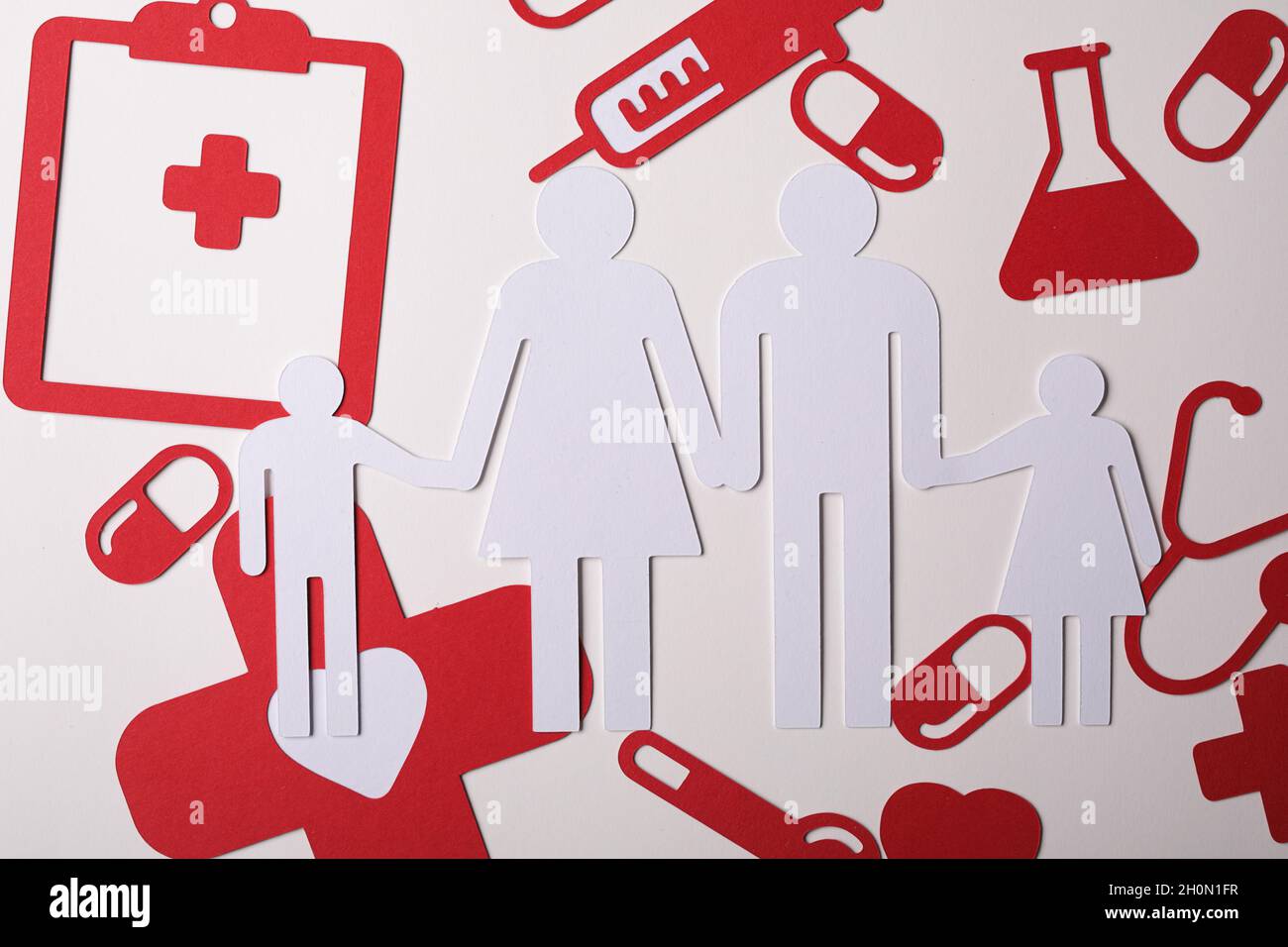 Close up shot of a red and white medical symbols and a family, parents ...