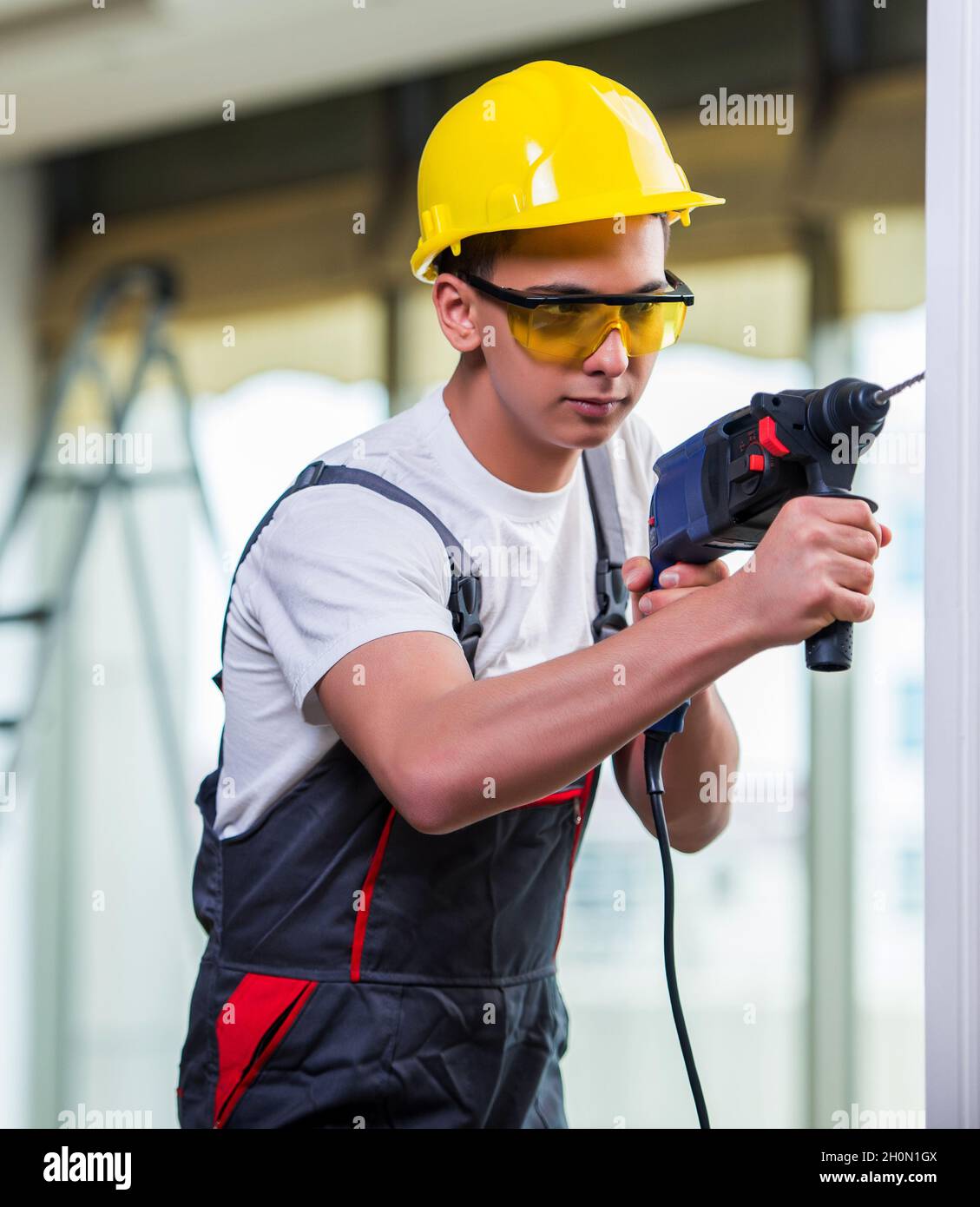 The man drilling the wall with drill perforator Stock Photo - Alamy
