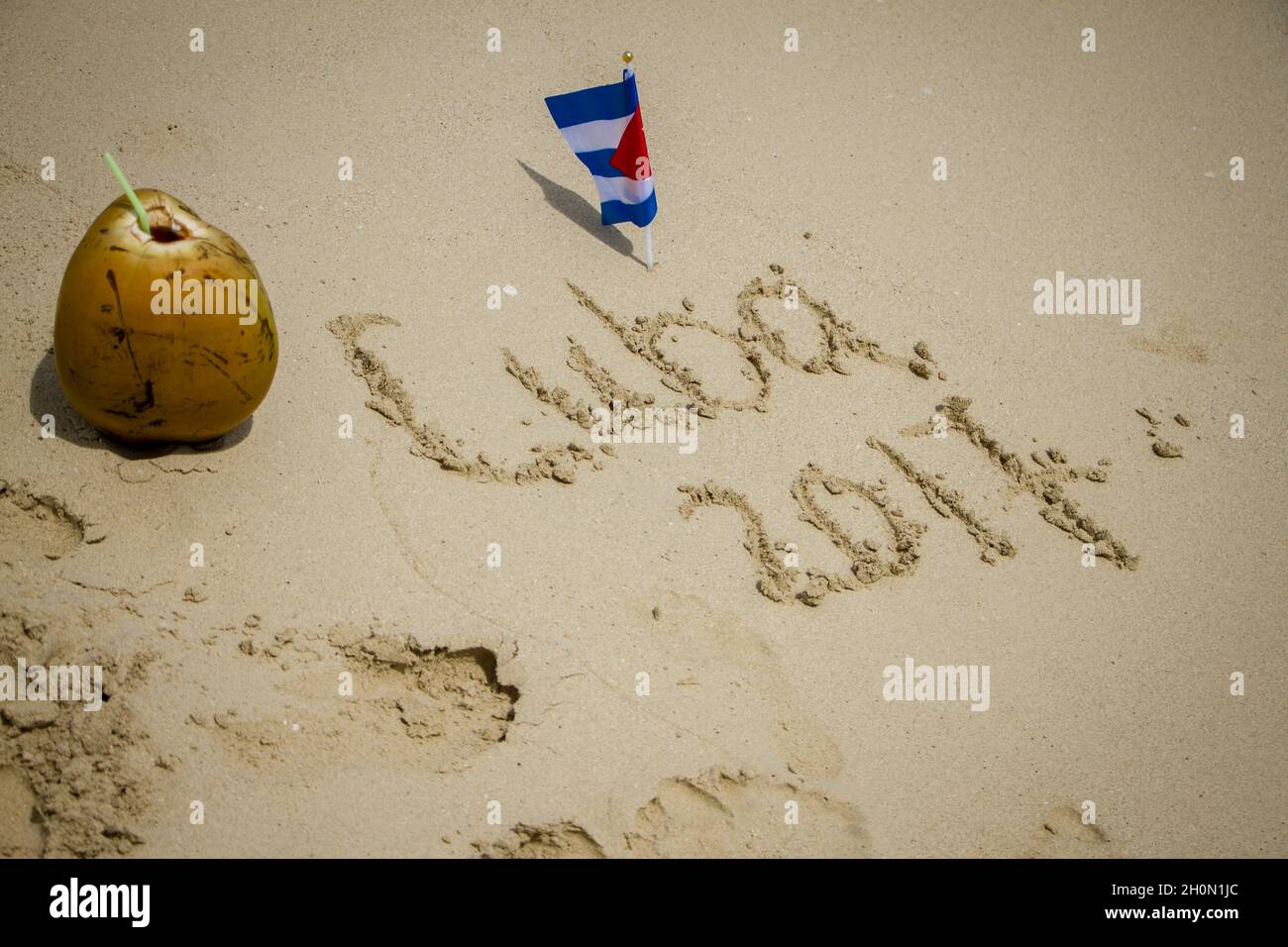 Coconut, the Cuban flag, and "Cuba 2017" carved on the wet sand at the ...