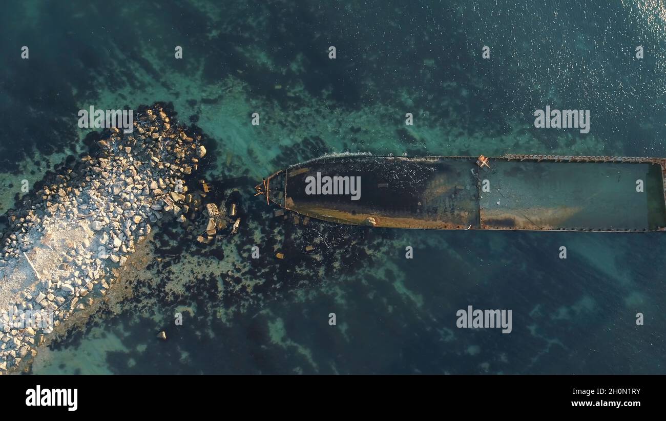 Aerial view of the rusty sunken ship stuck on a rocky shoal. Old ...