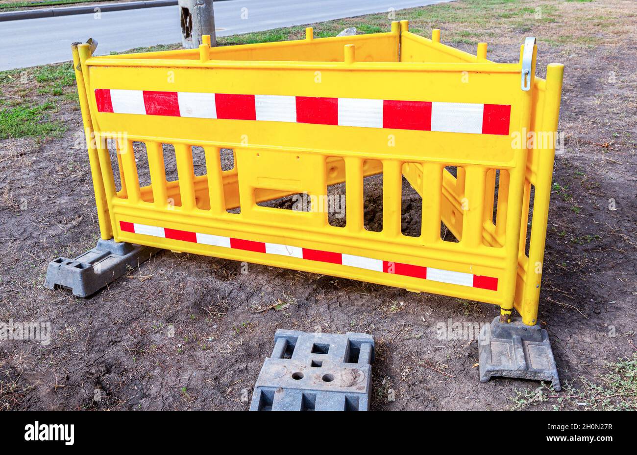 Yellow plastic fence at construction site. Road works traffic sign at ...