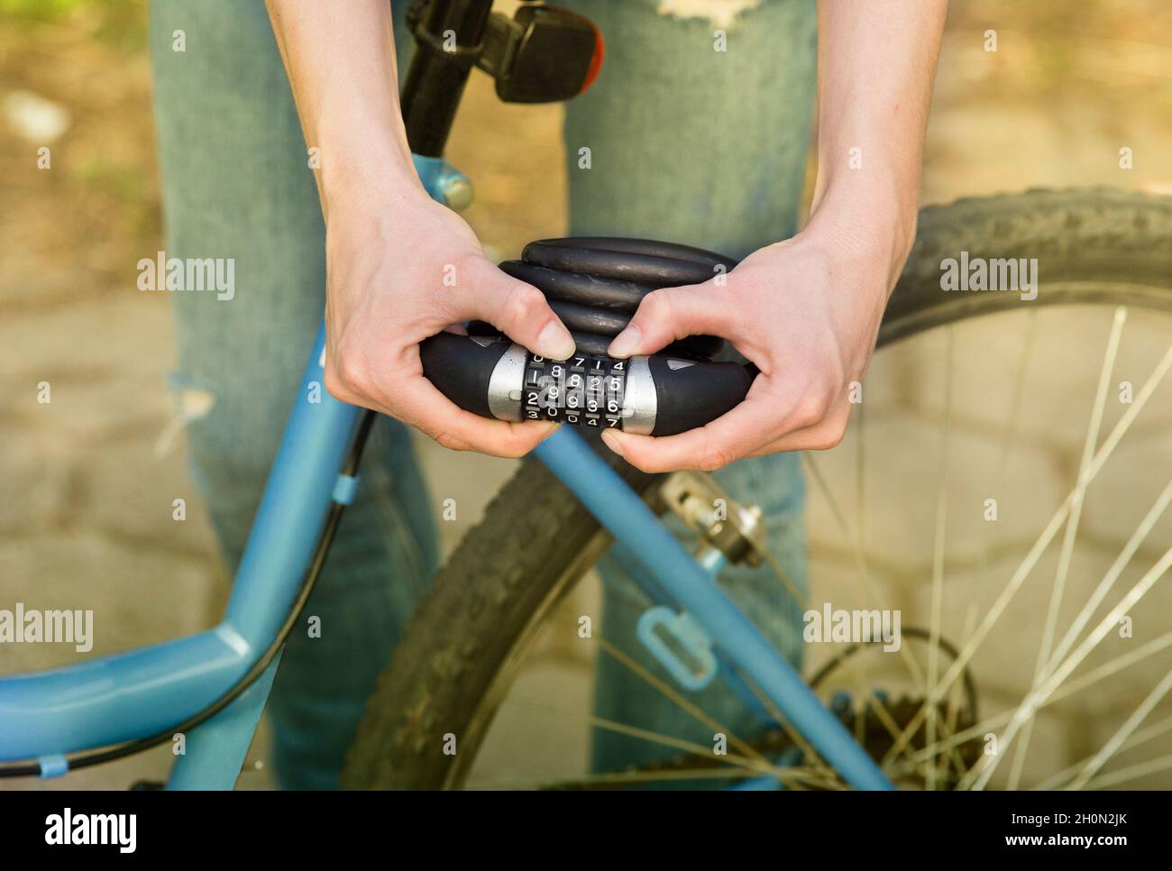 Close up of female hands holding combination bike lock in front of ...