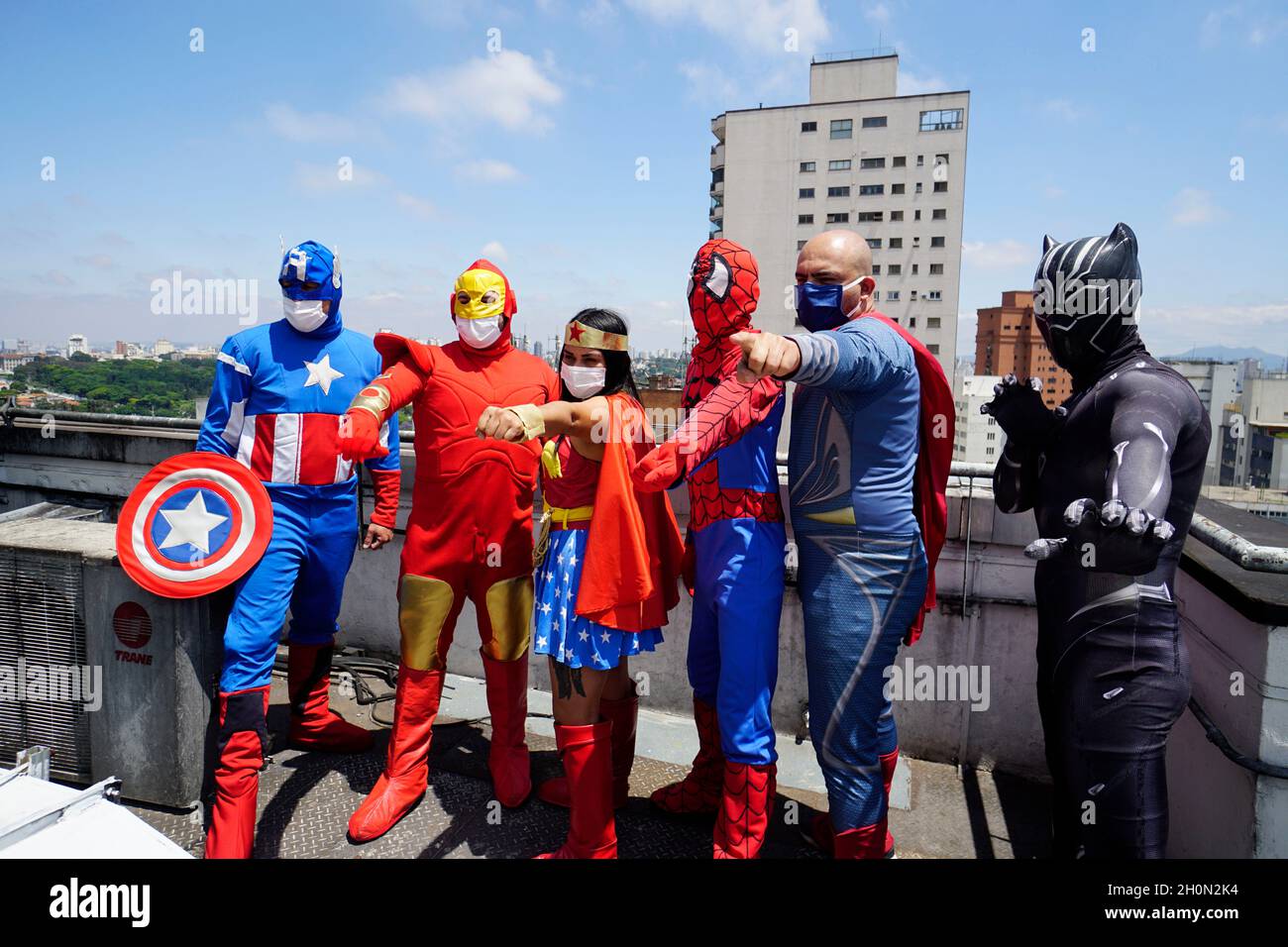 October 12, 2021: Window cleaners wearing superhero costumes greet a ...