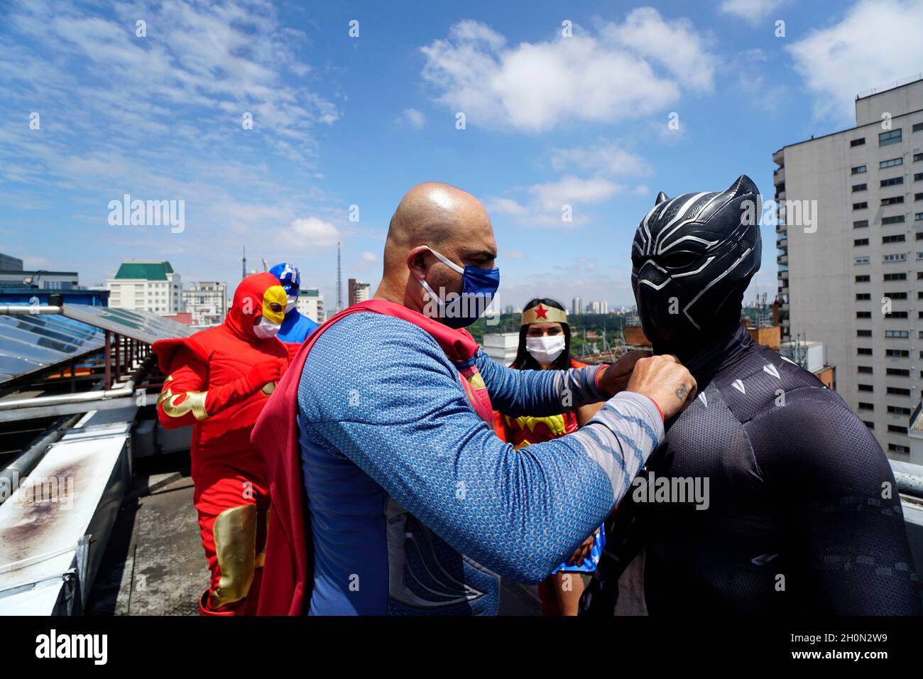 October 12, 2021: Window cleaners wearing superhero costumes greet a ...