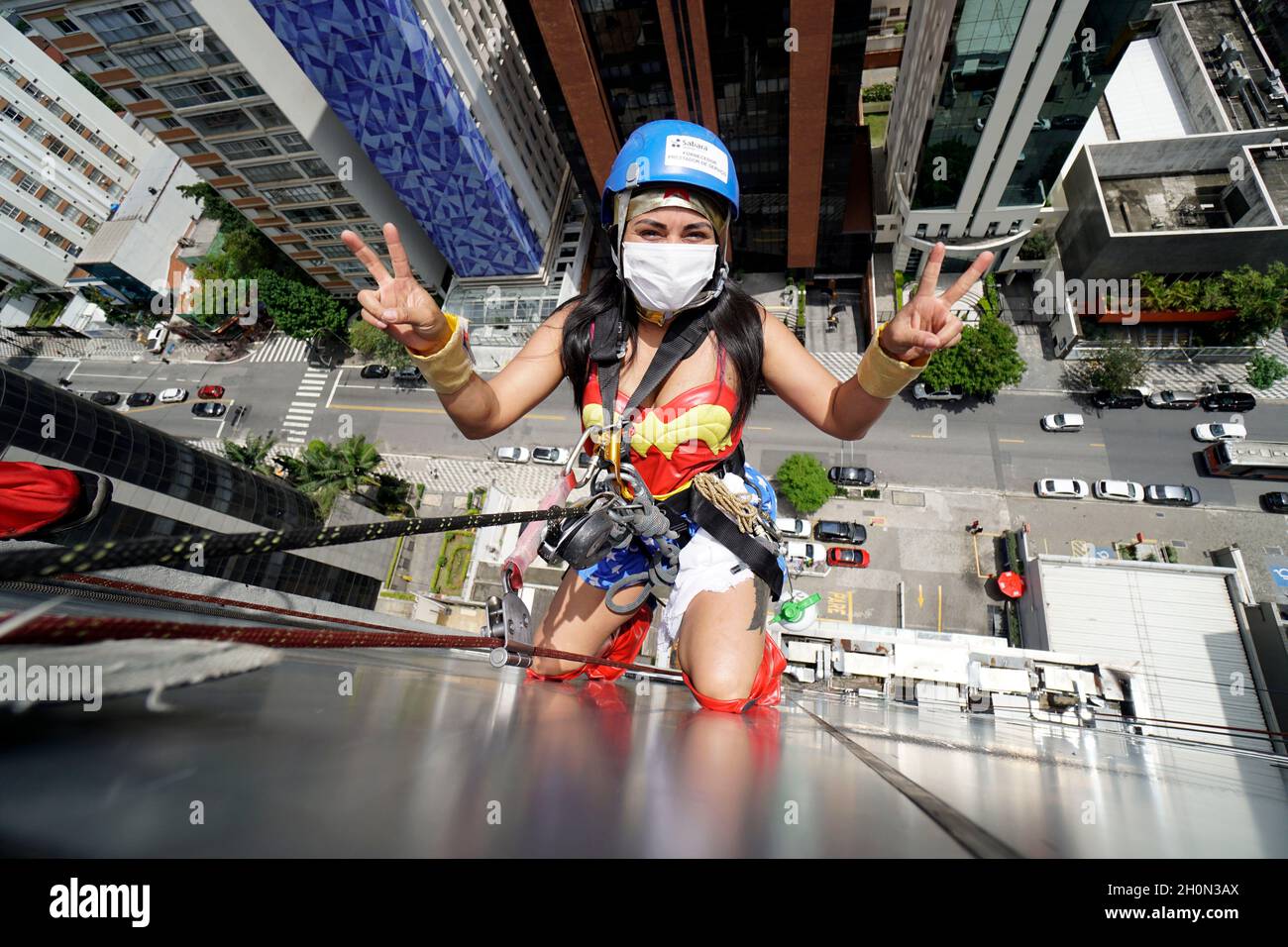 October 12, 2021: Window cleaners wearing superhero costumes greet a ...