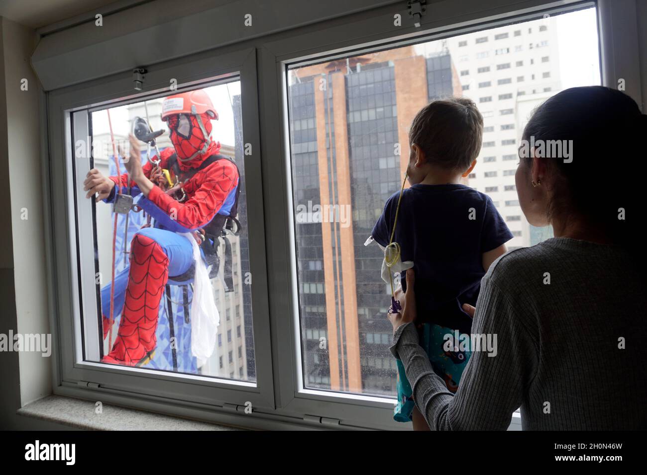 October 12, 2021: Window cleaners wearing superhero costumes greet a ...