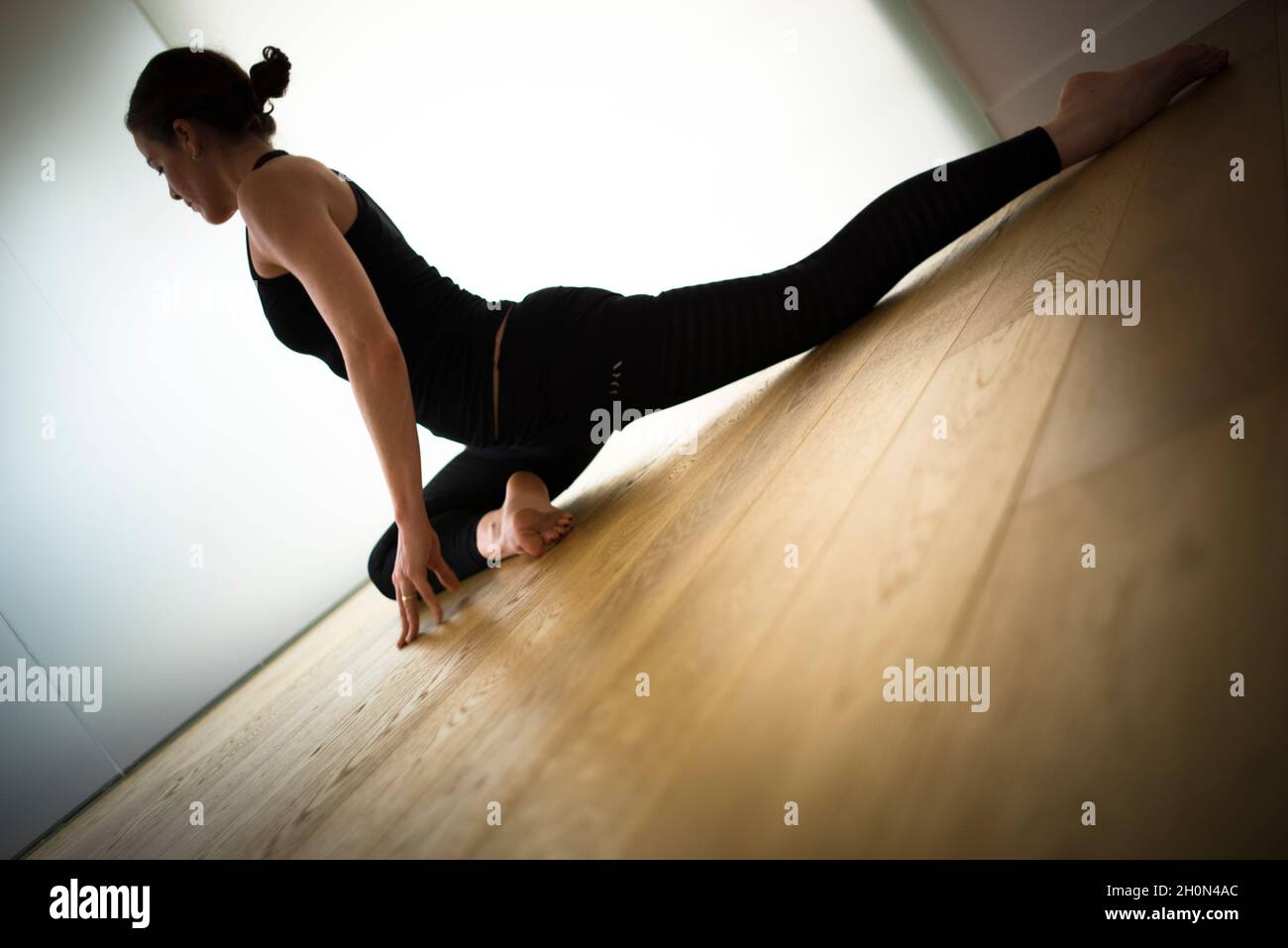 Woman yoga teacher in fitness studio stretching and doing exercise ...