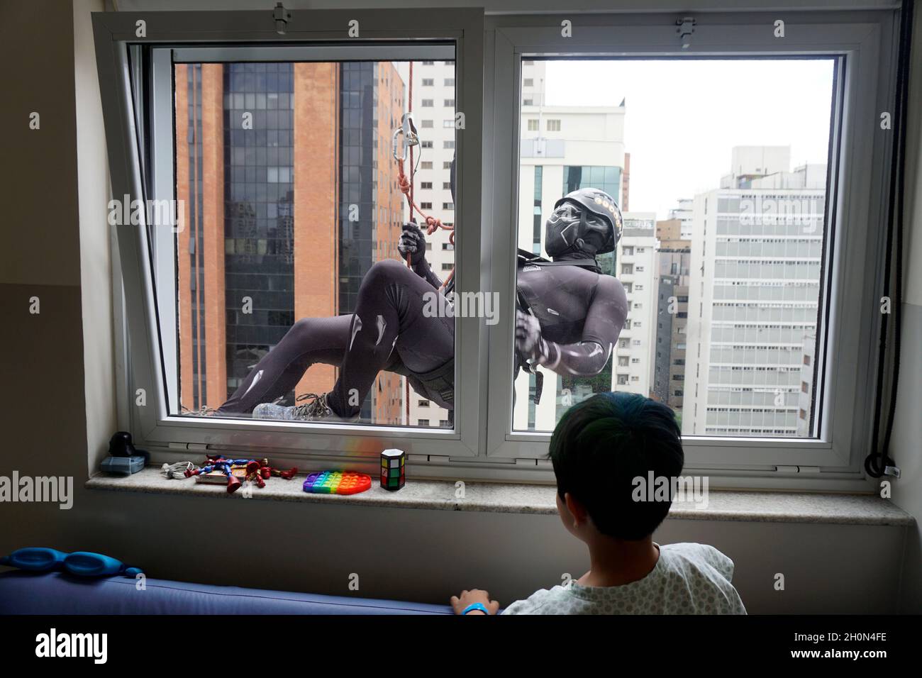 October 12, 2021: Window cleaners wearing superhero costumes greet a ...