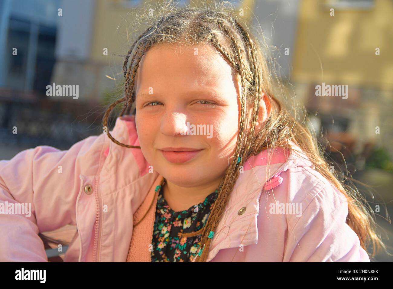 Portrait of little girl with Afro-pigtails gathered in a tail. Hippie ...