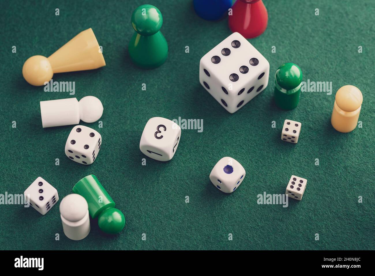 Colored board game figures with dice. Board games concept Stock Photo ...