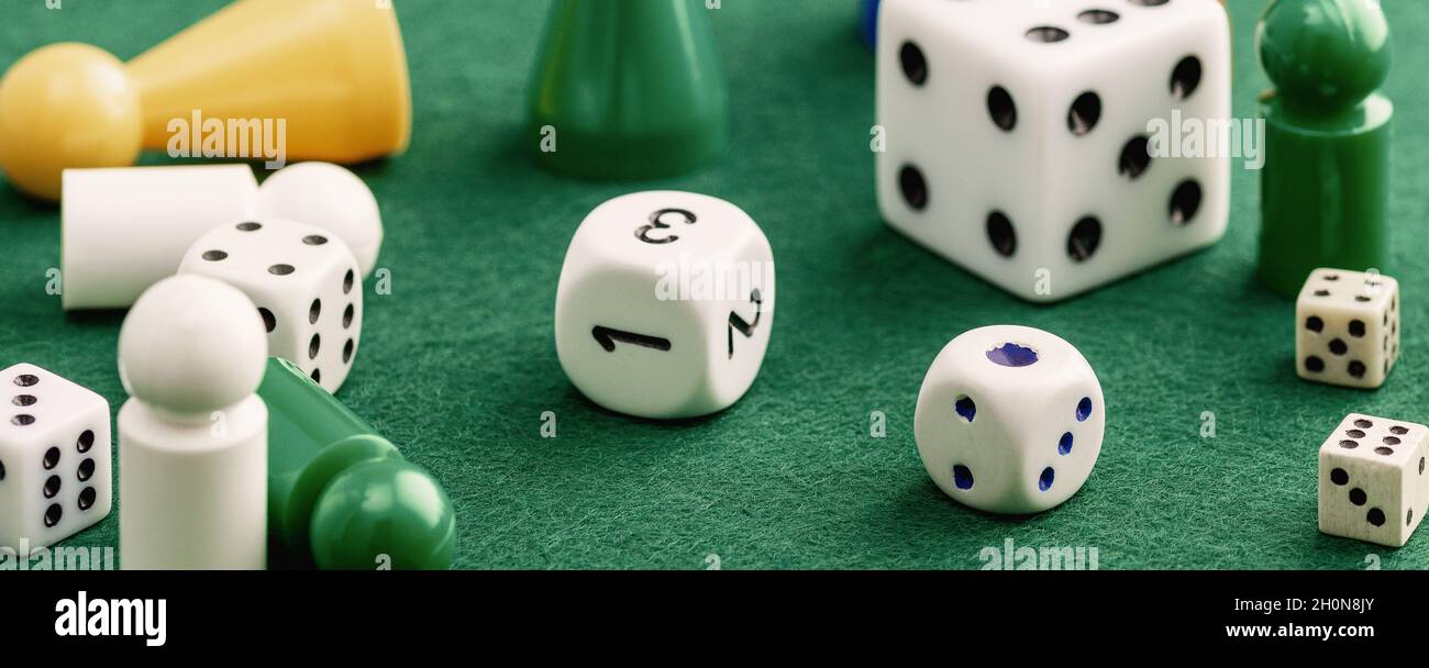 Colored board game figures with dice. Board games concept Stock Photo ...