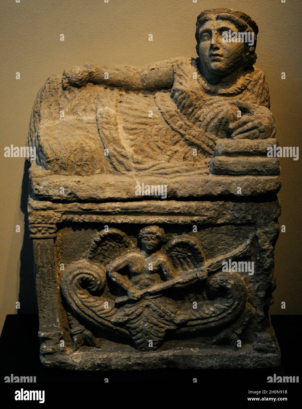 Roman cinerary urn with a reclining female figure at the top. On the ...