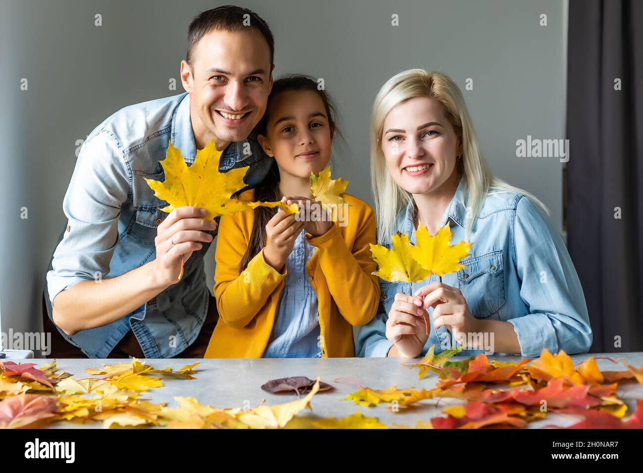 family At Home Doing Craft And Making Picture From Leaves In Kitchen ...