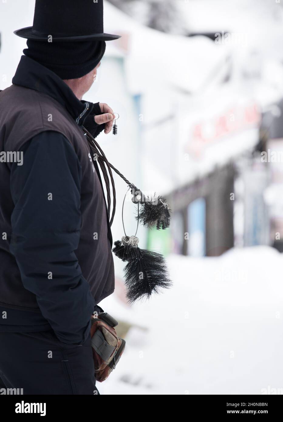 Side view of chimney sweeper with brooms on cold snowy day. Good luck ...