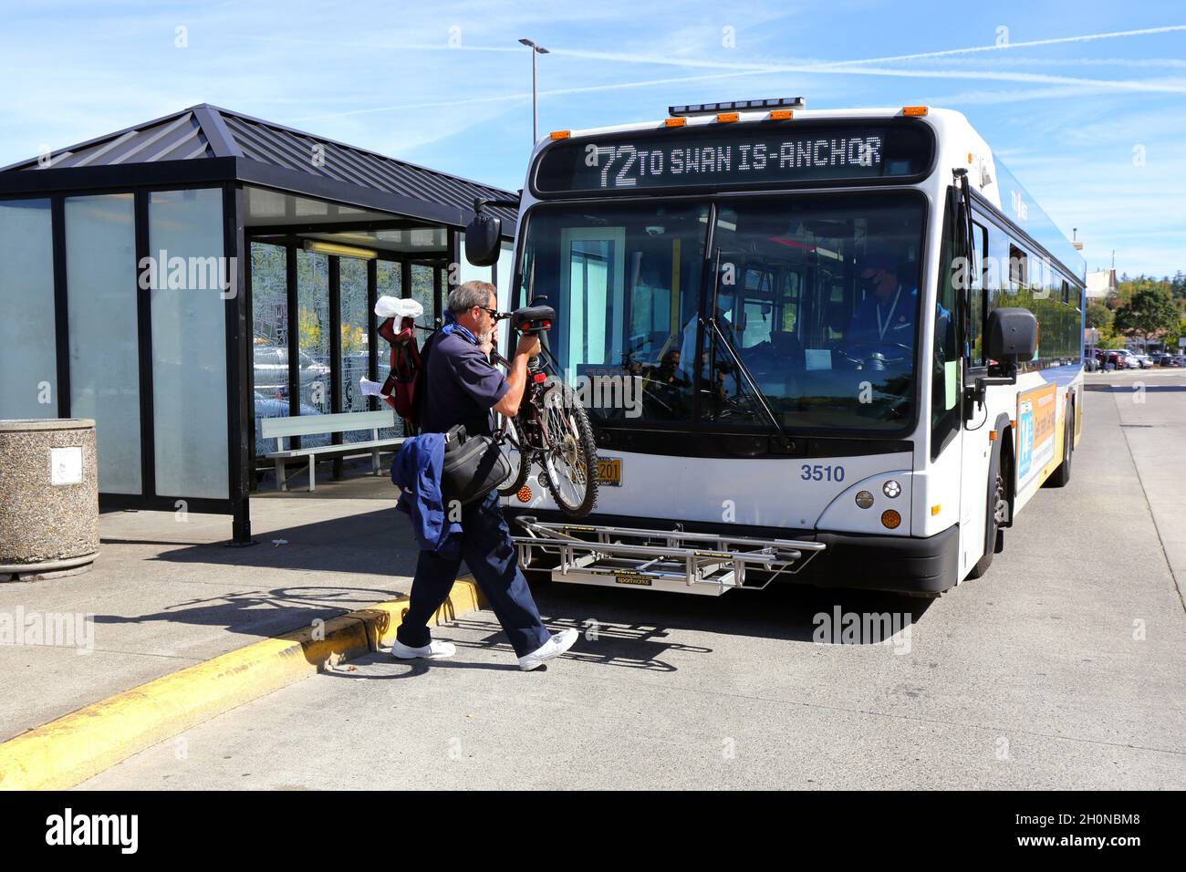 A person putting a bicycle on the bike rack of a Trimet bus. At ...