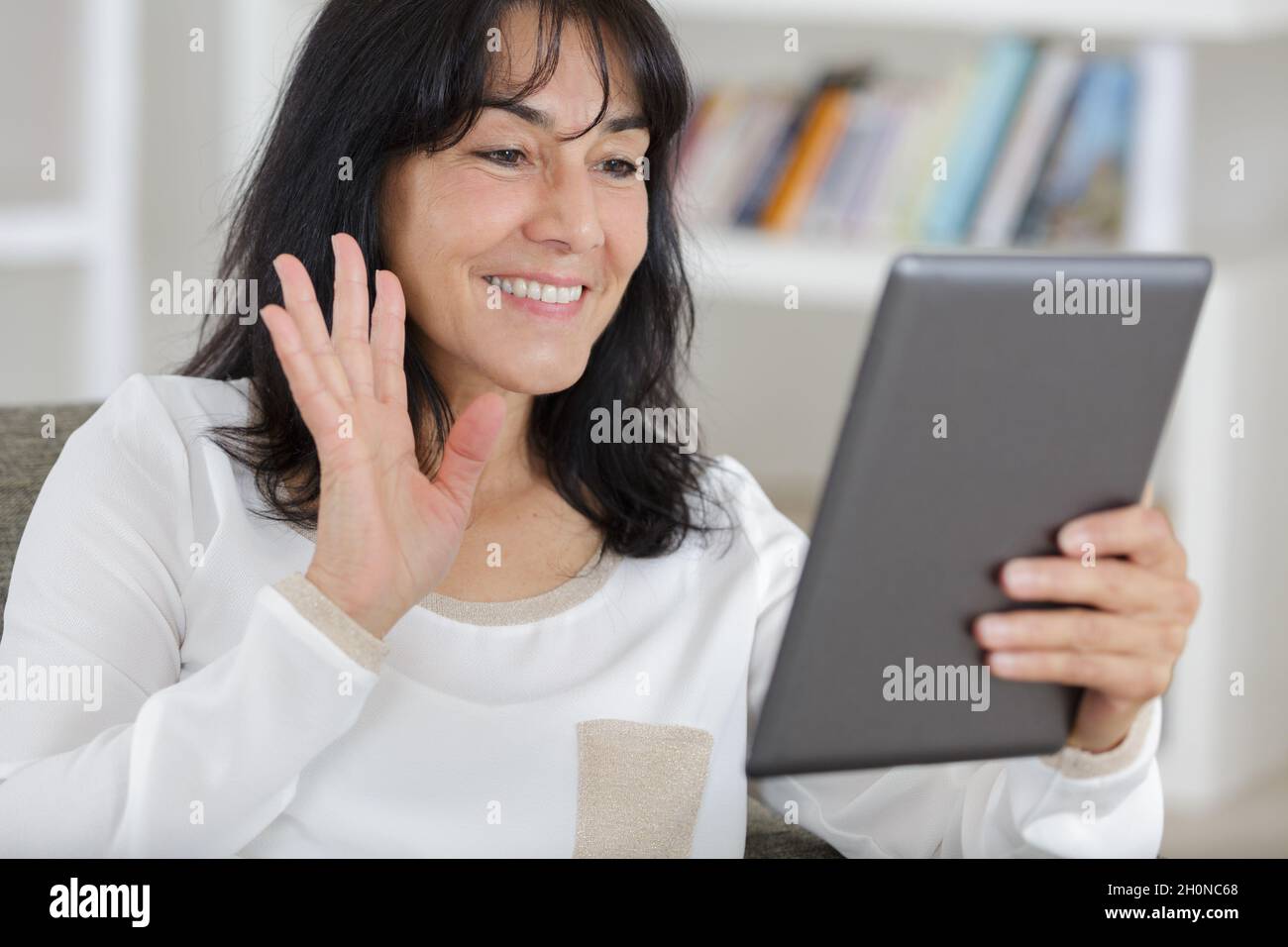 happy woman waving hand while video calling Stock Photo - Alamy