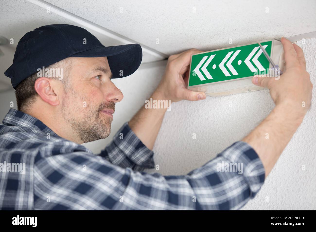 man installing an exit sign Stock Photo - Alamy