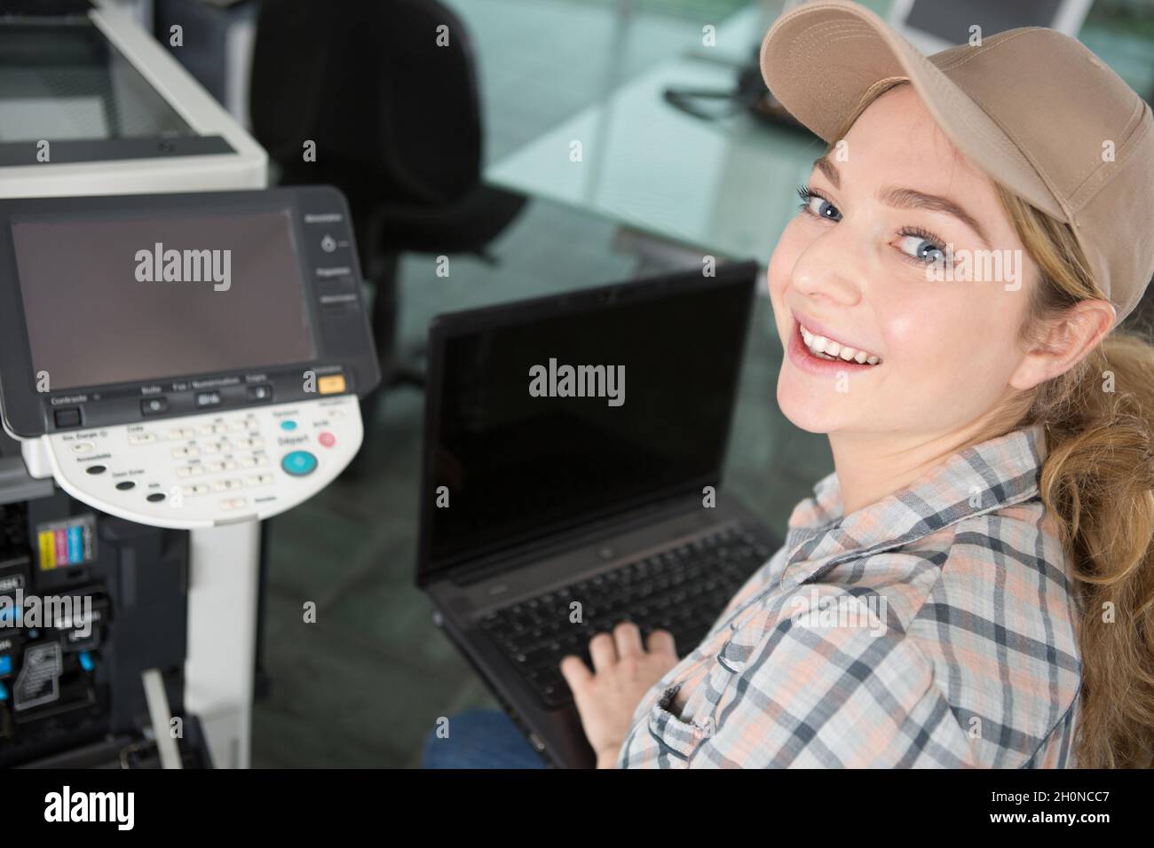 happy woman smiling at the camera fixing a printer Stock Photo - Alamy