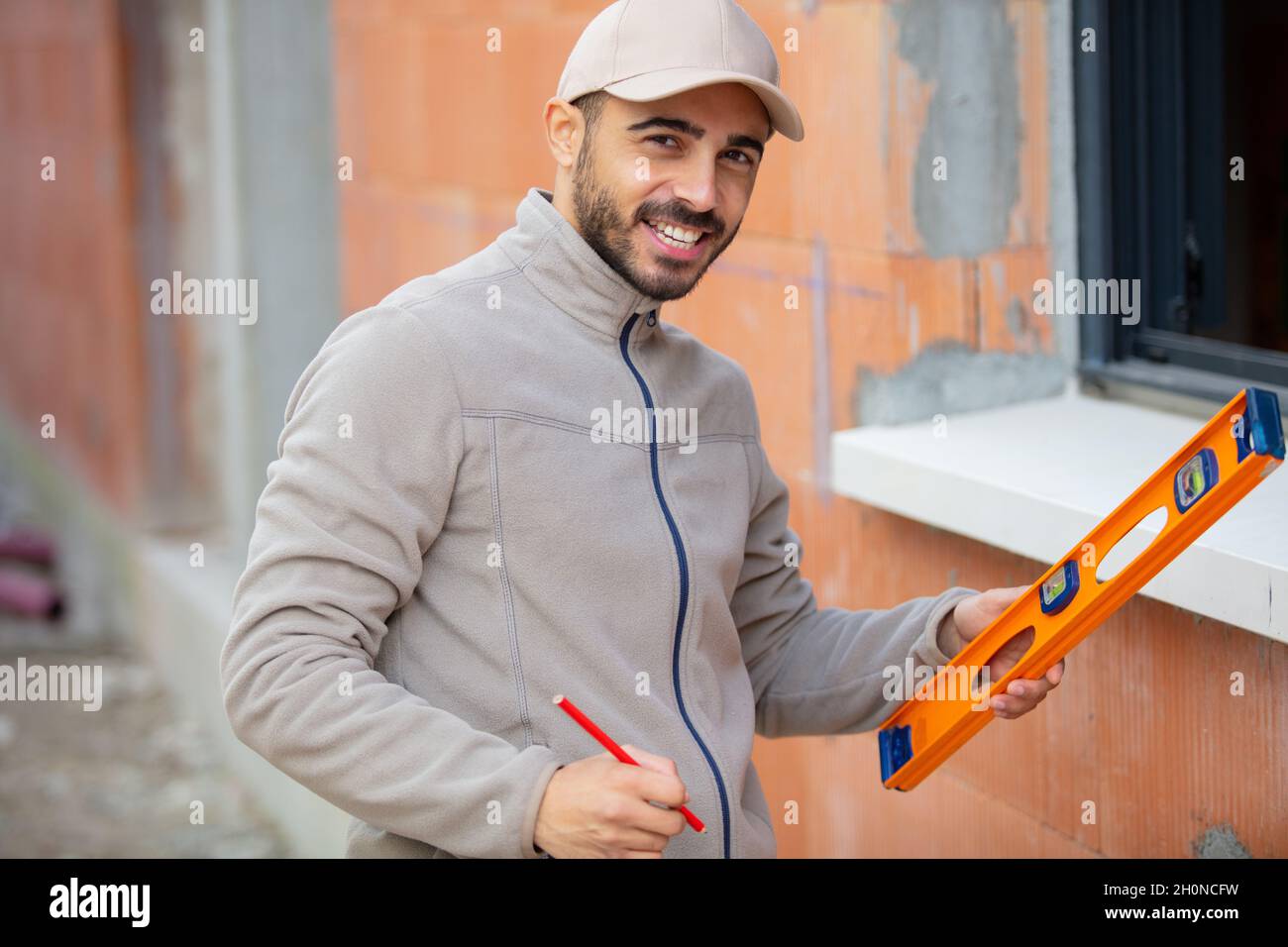 construction worker using spirit level in a new house Stock Photo - Alamy