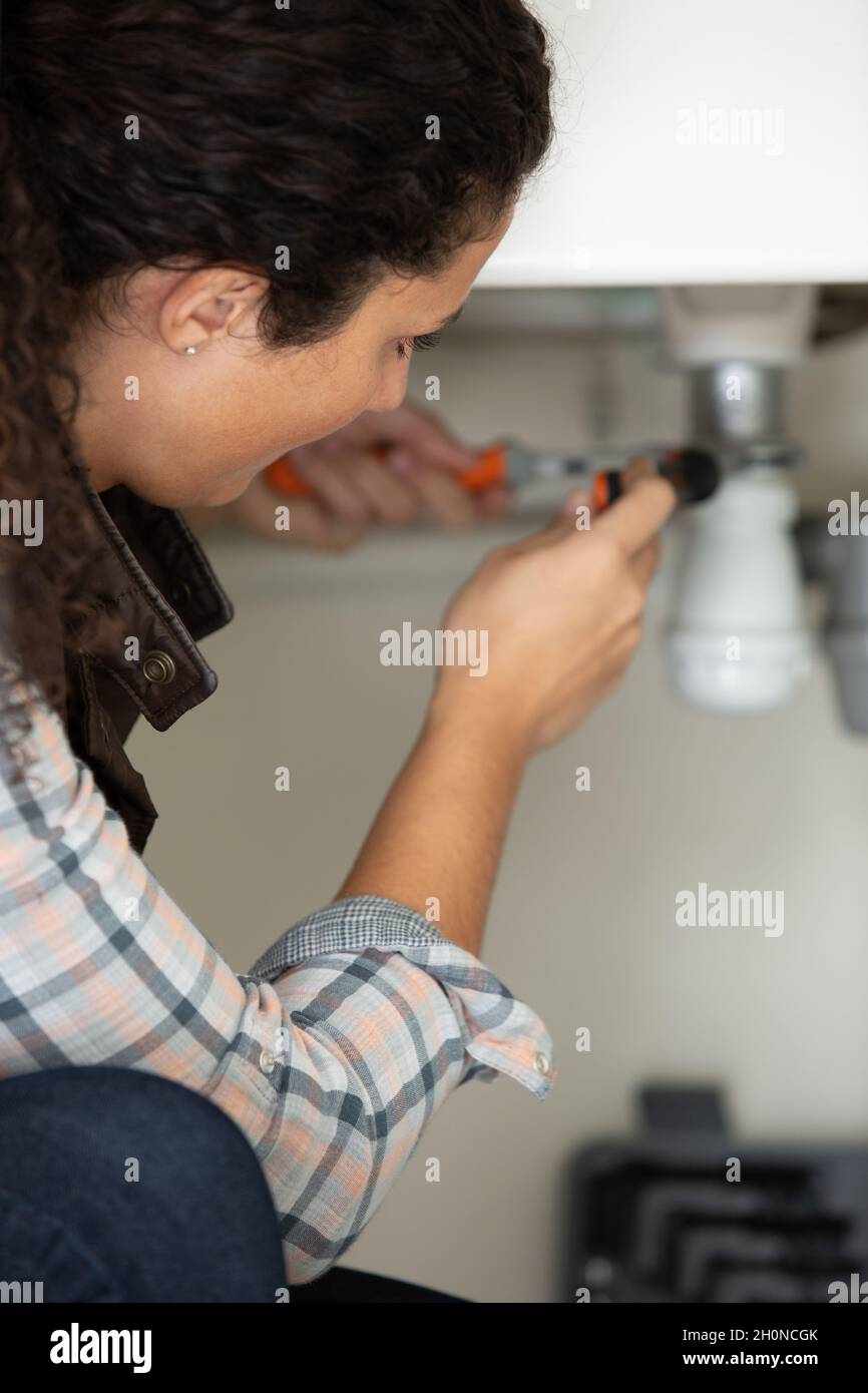 woman tightening pipe under sink with worktool at home Stock Photo - Alamy
