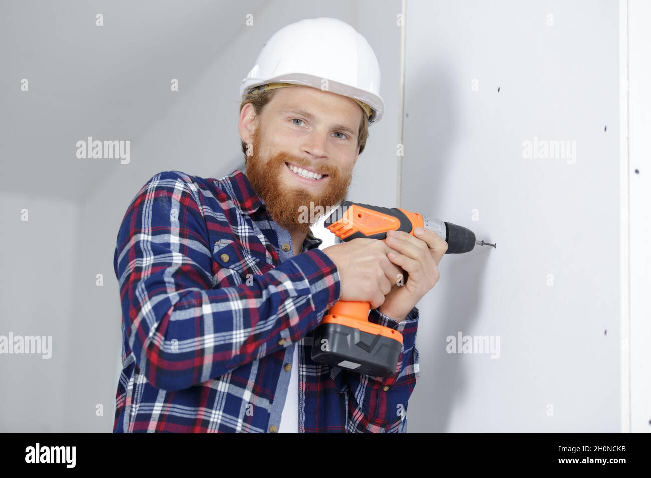 a man drills a wall with a cordless drill Stock Photo - Alamy