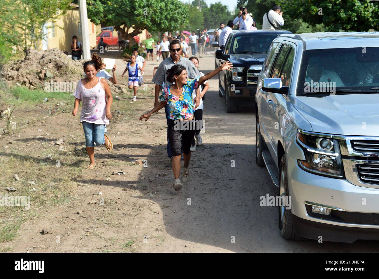 An adult woman in extreme poverty runs happily followed by a Suburban ...