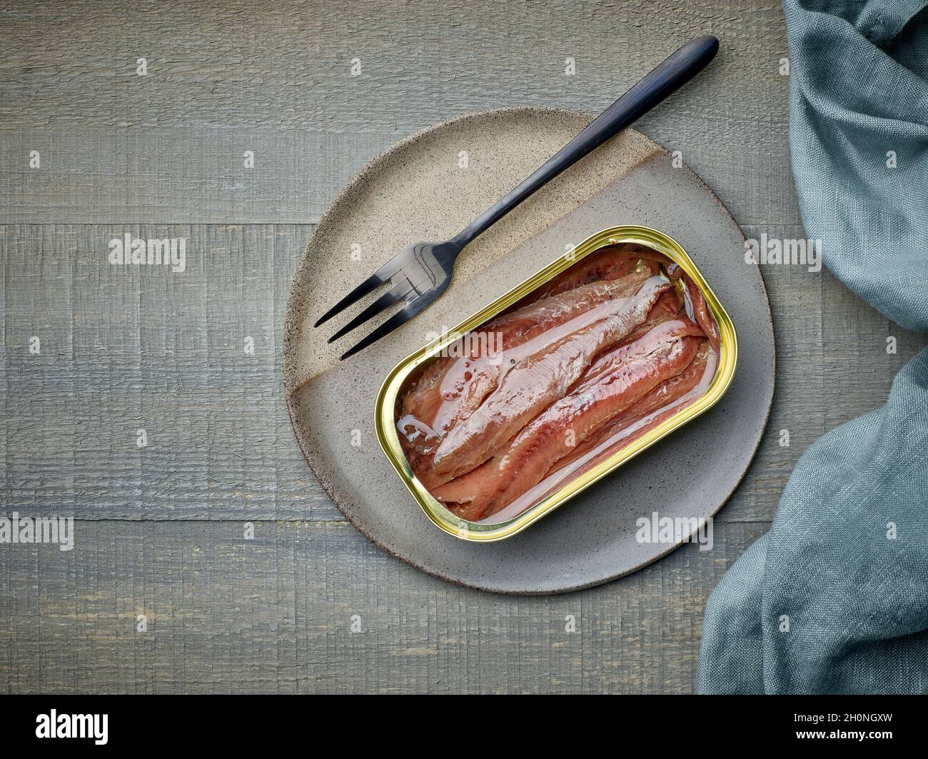 canned anchovy fillets and fork on wooden kitchen table, top view Stock ...