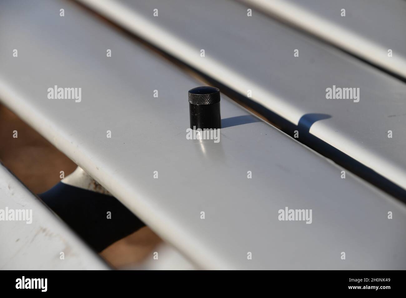 Black micro geocache. container sits on a silver bench Stock Photo - Alamy