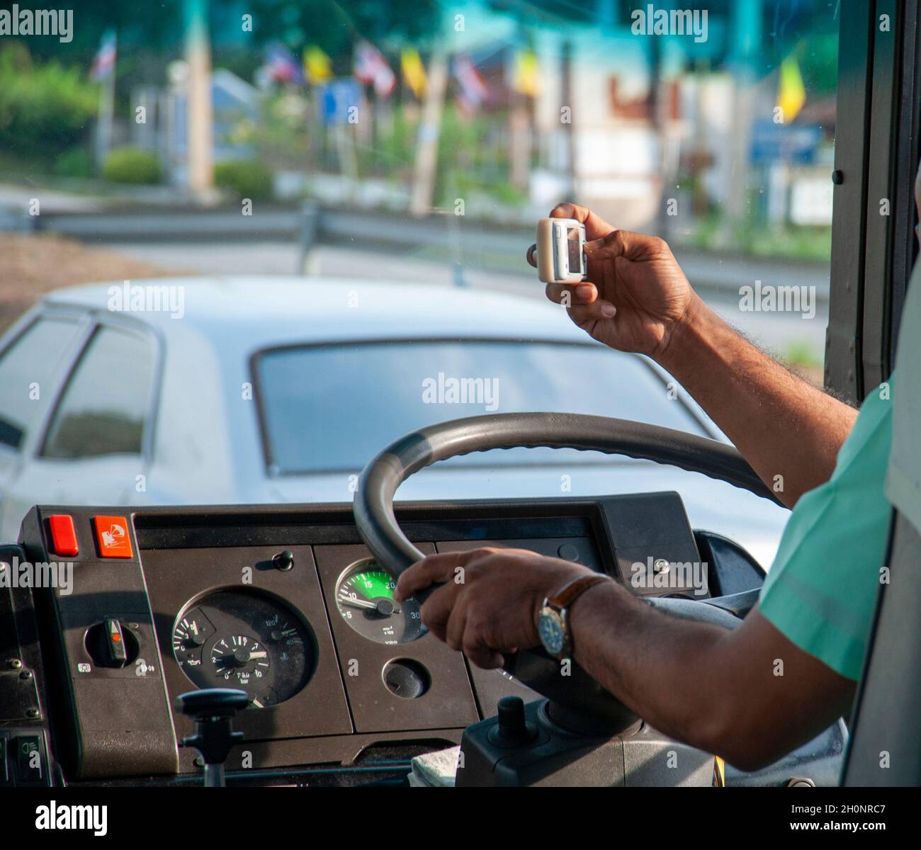 Driver using a mobile camera while driving a bus Stock Photo - Alamy