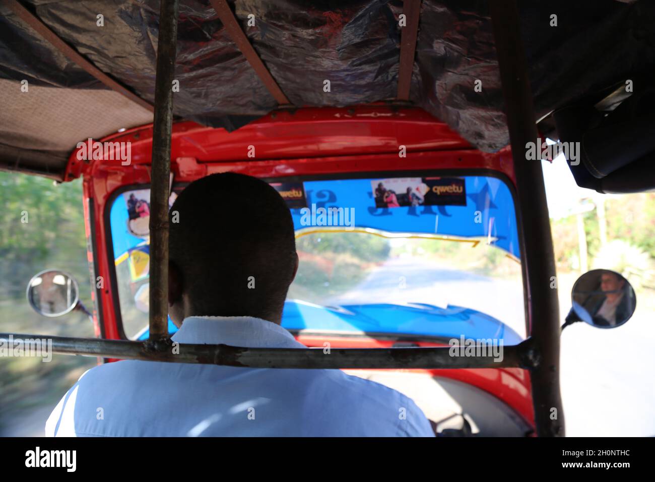 UKUNDA, KENYA - Dec 08, 2016: A back view of a male riding a tuk-tuk on ...