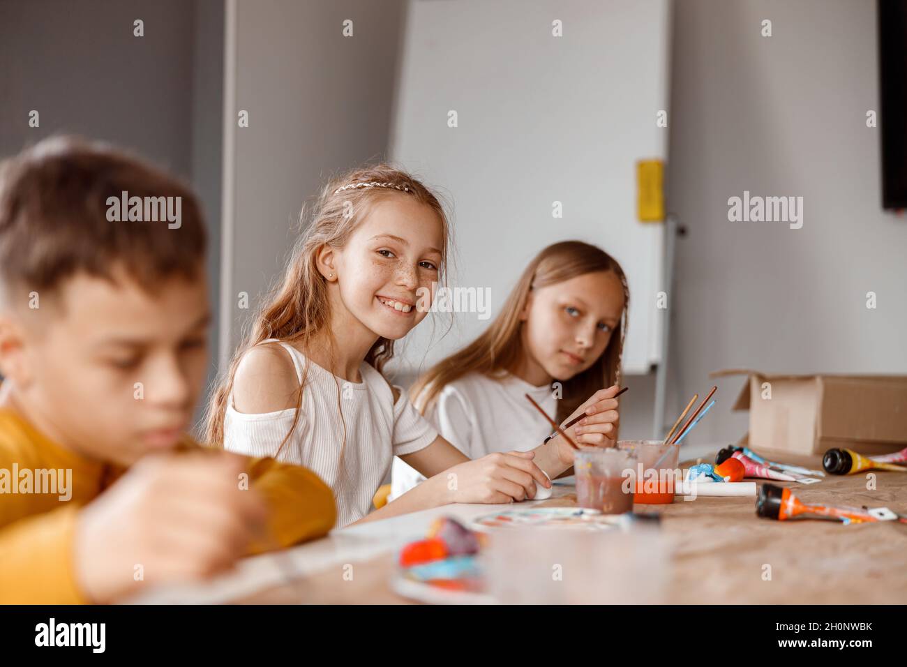 Smiling pupils painting on paper with colorful paints Stock Photo - Alamy