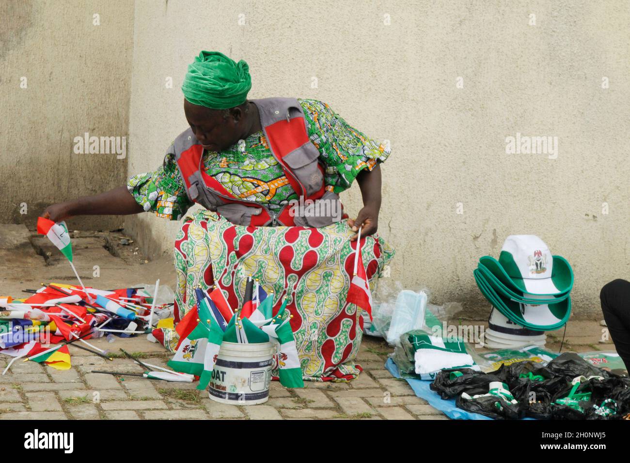 A woman arranges her caps, flags and other souvenirs during Nigeria’s ...