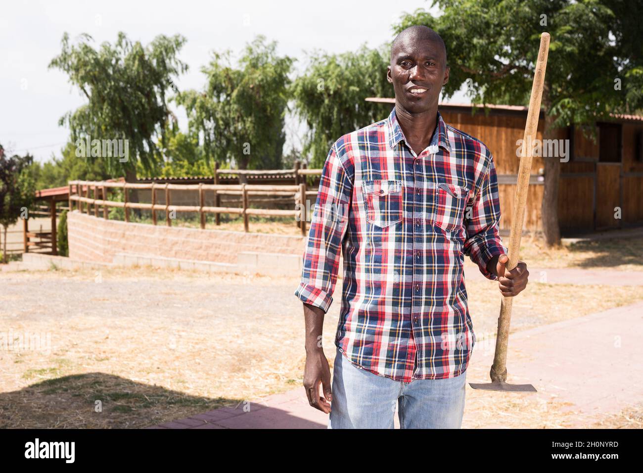 Young african american man farmer with rake standing at farm Stock ...