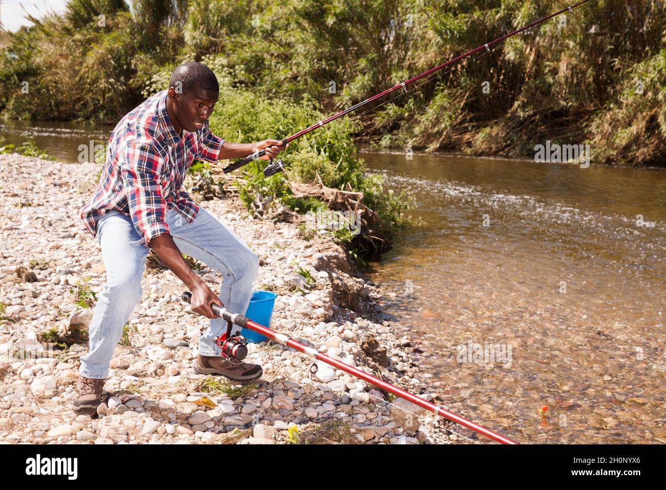 Fisherman pulling fish Stock Photo - Alamy