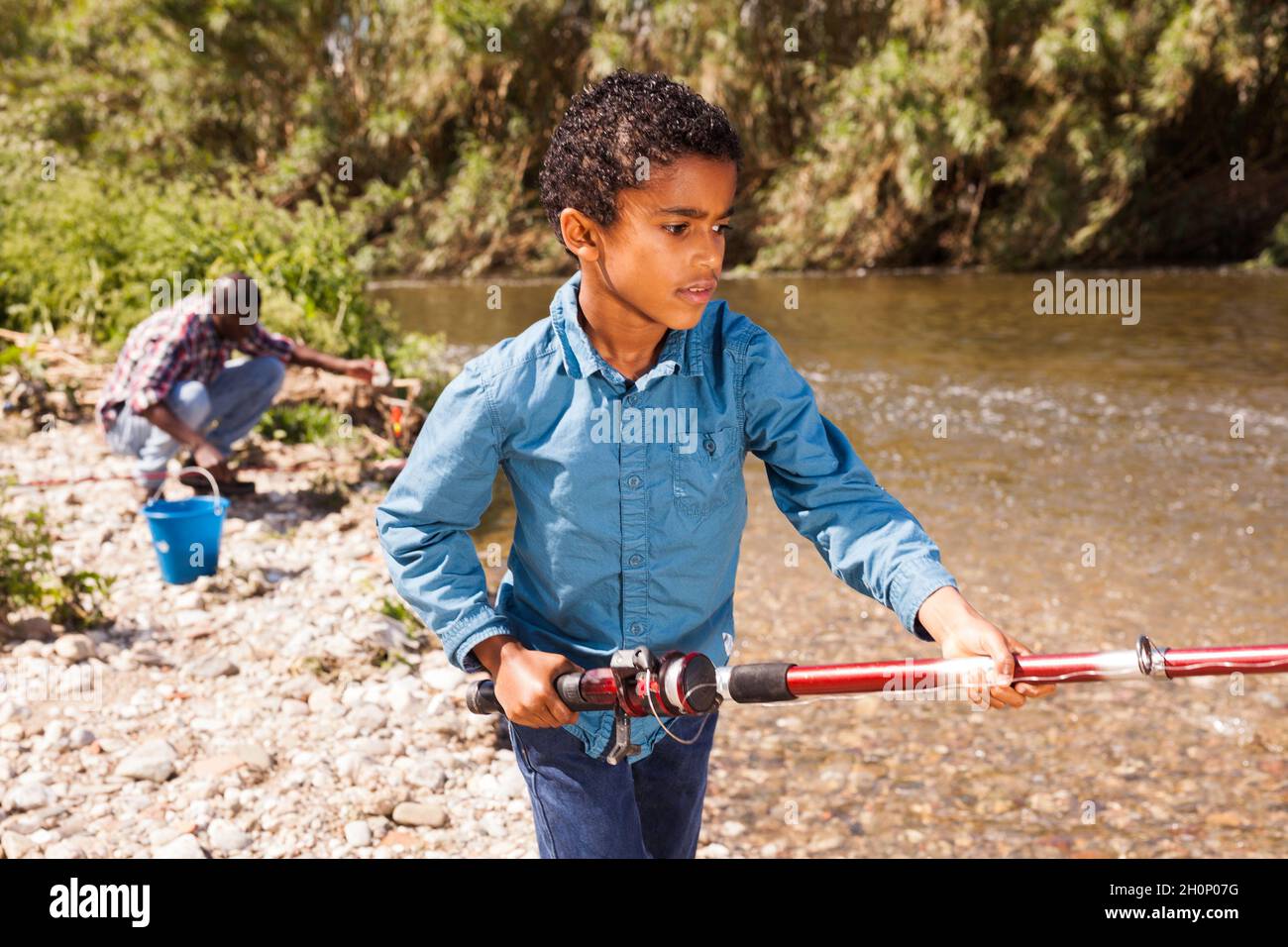 Afro boy pulling fish Stock Photo - Alamy