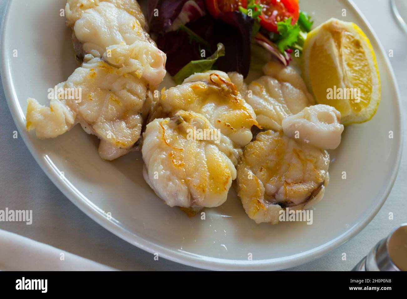Baked pieces of monkfish Stock Photo - Alamy