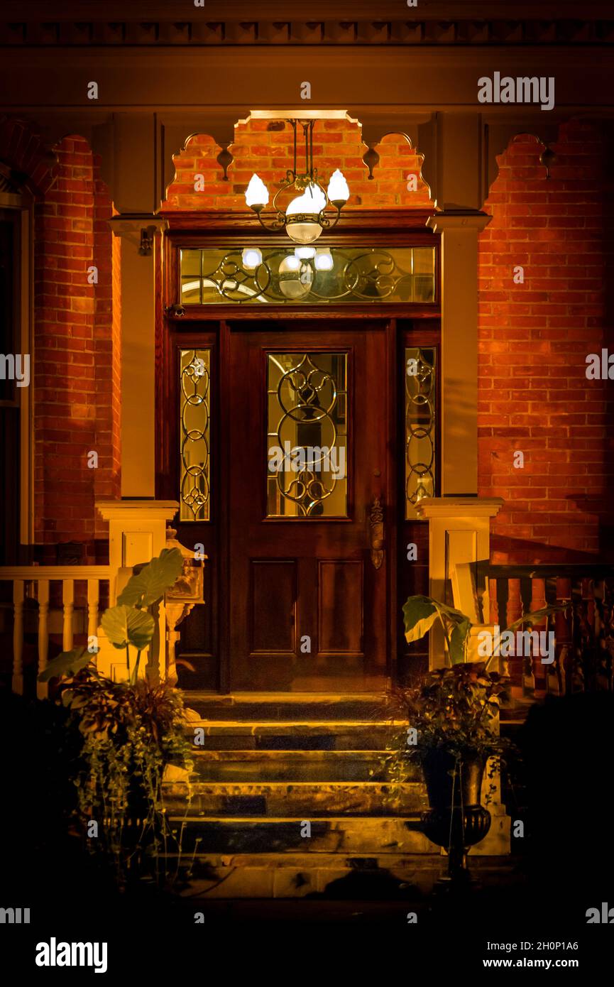 Door of a mansion with doorsteps and porch lit at night Stock Photo - Alamy
