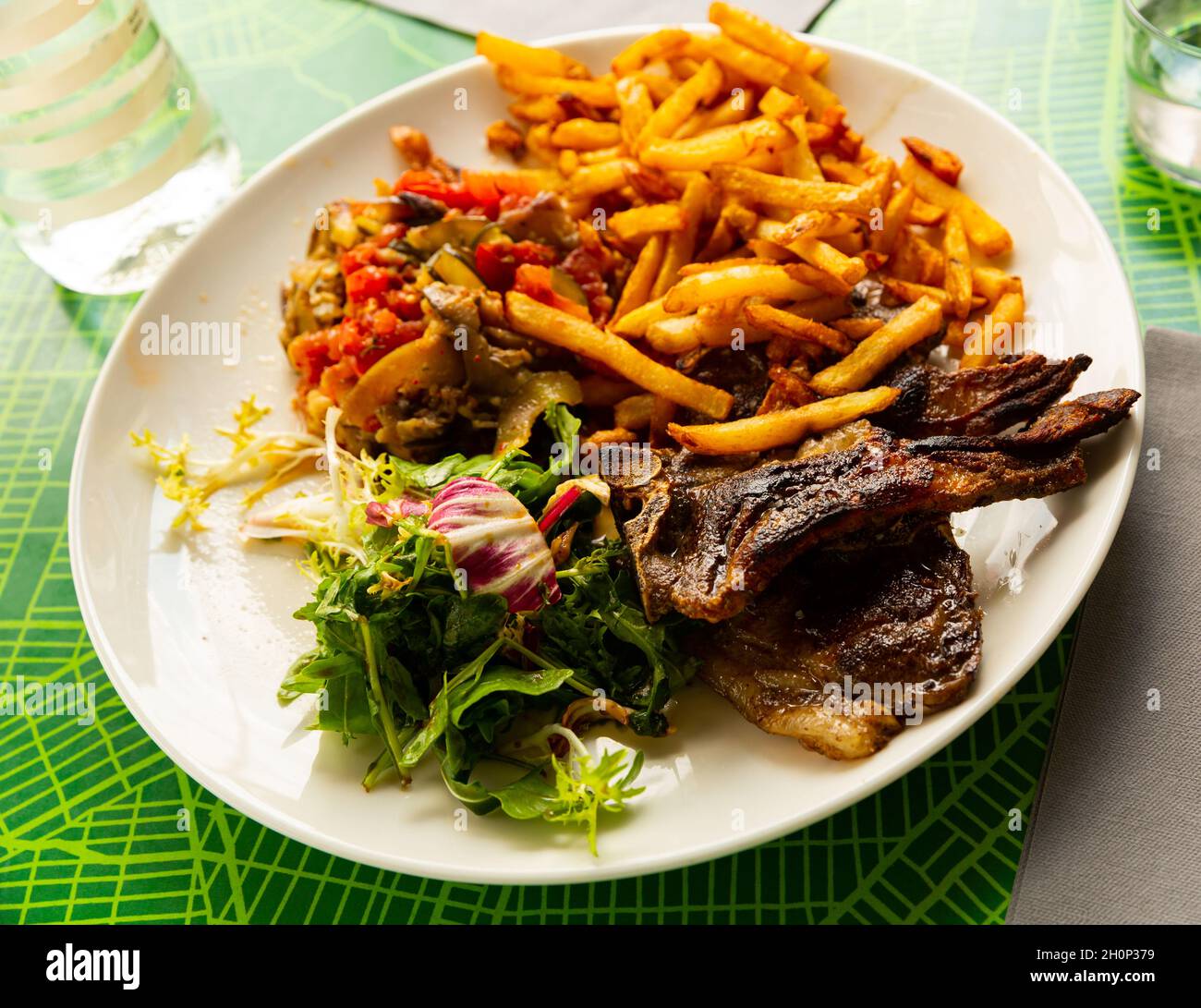Grilled of lamb served with french fries and vegetable garnish Stock ...