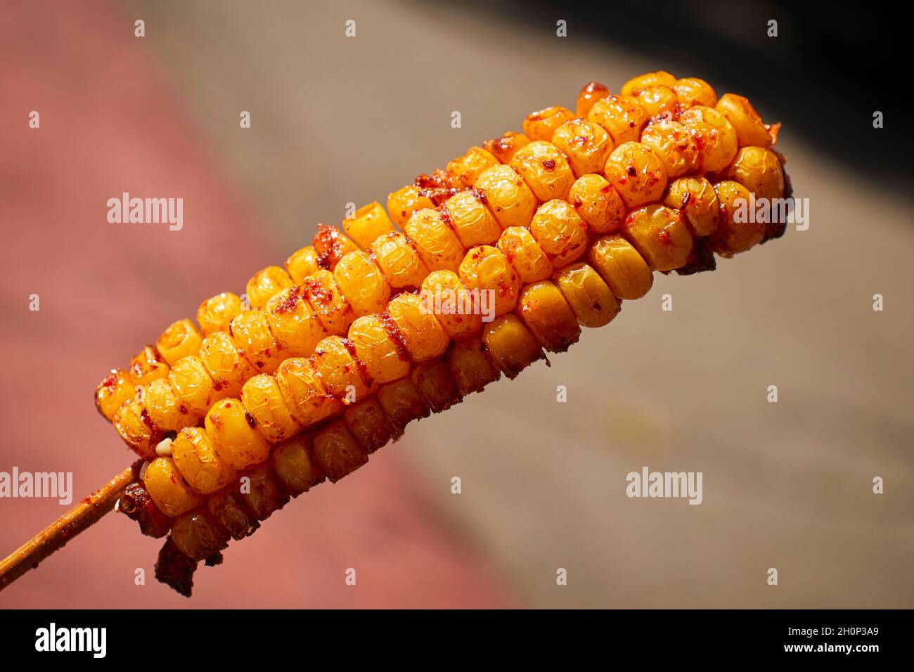 Deep fried corn kernels on a stick. A snack sold by a vendor in ...