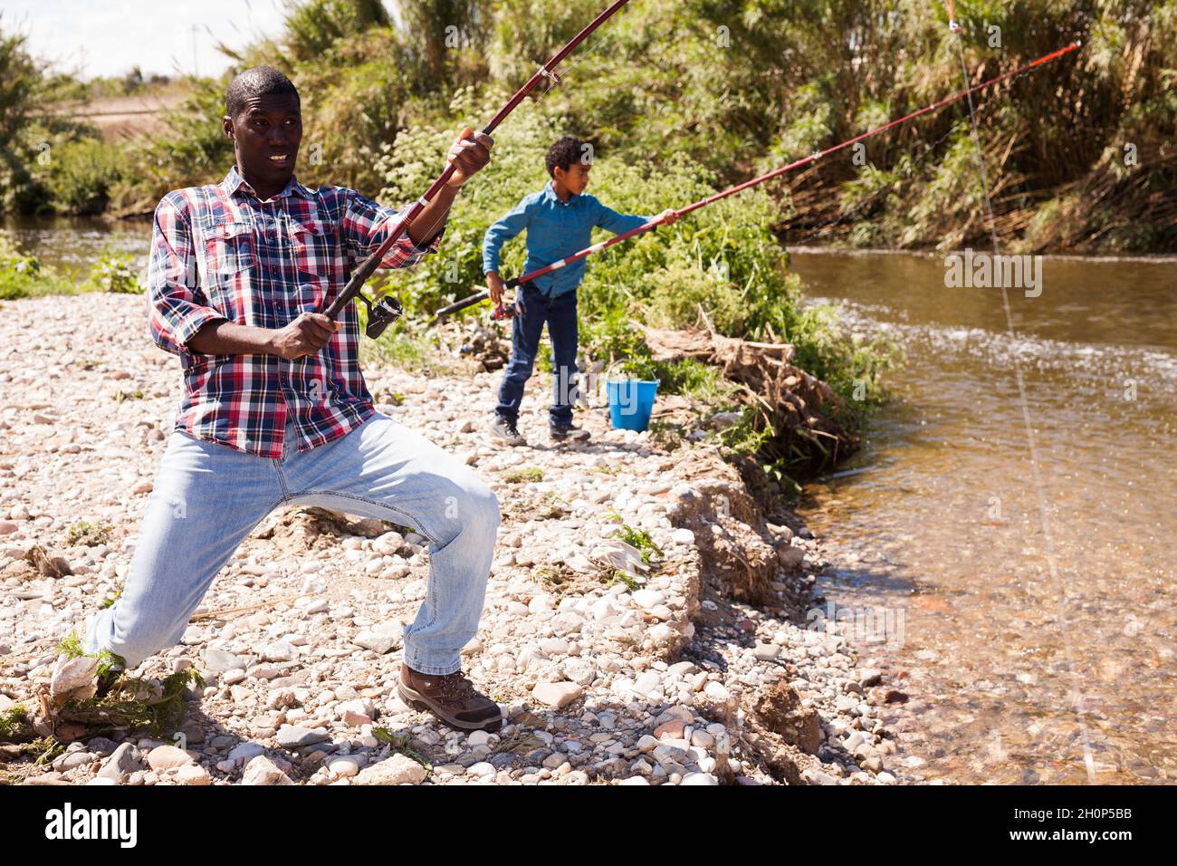 Man fishing and pulling fish Stock Photo - Alamy