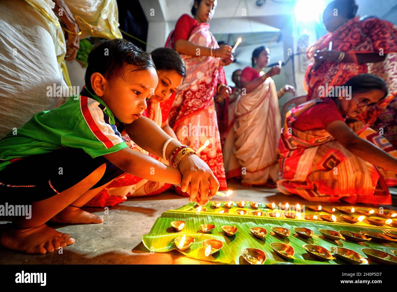 Kolkata, India. 13th Oct, 2021. Hindu devotees light Diyas (clay lamps ...