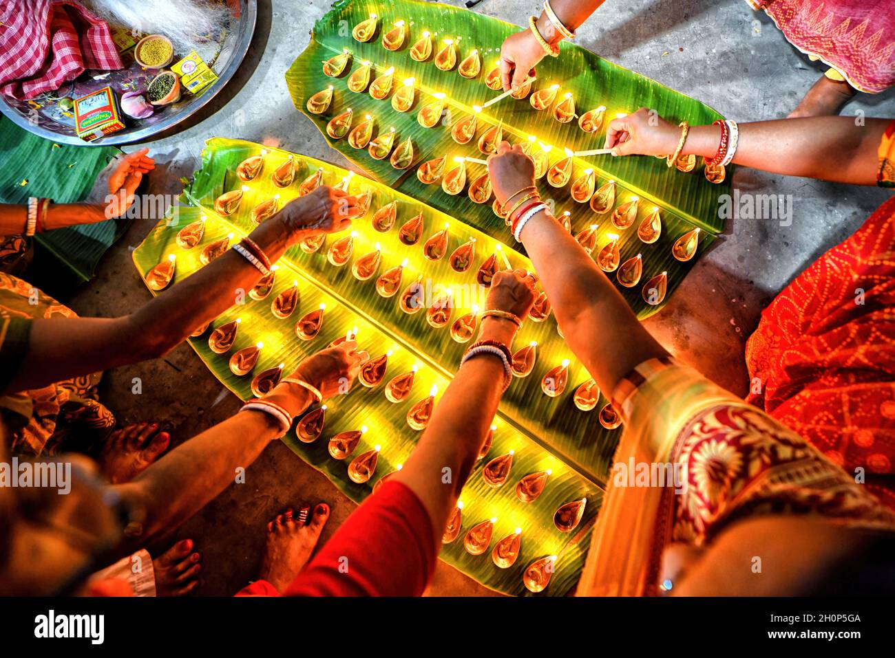 Kolkata, India. 13th Oct, 2021. Hindu devotees light Diyas (clay lamps ...