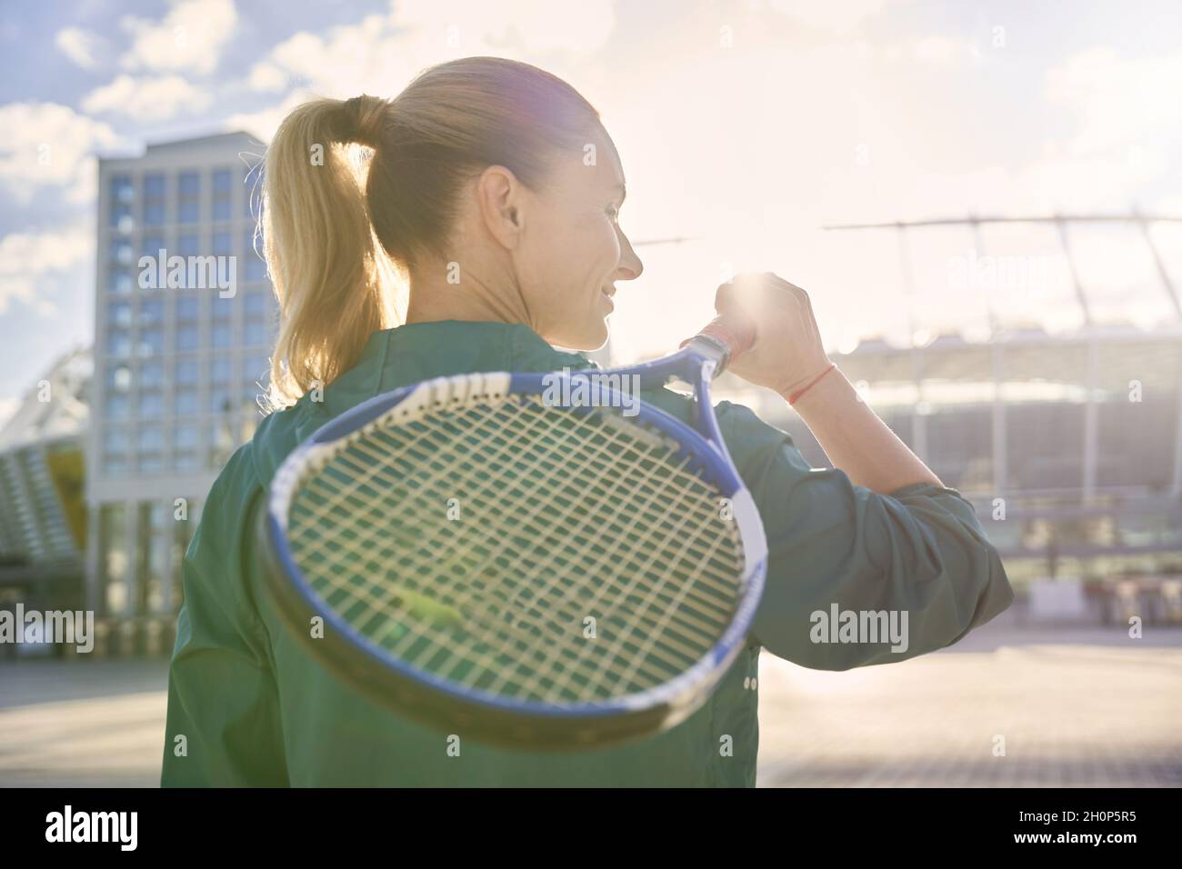 Rear view of woman, professional tennis player walking with tennis ...