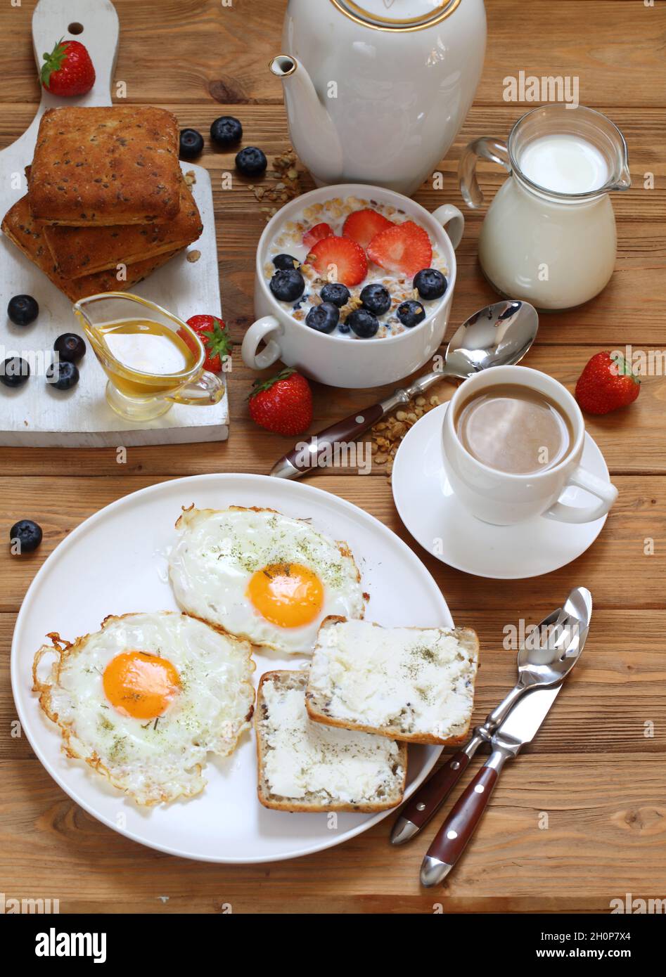 Scrambled eggs with ricotta sandwiches, muesli with milk and fruits on ...