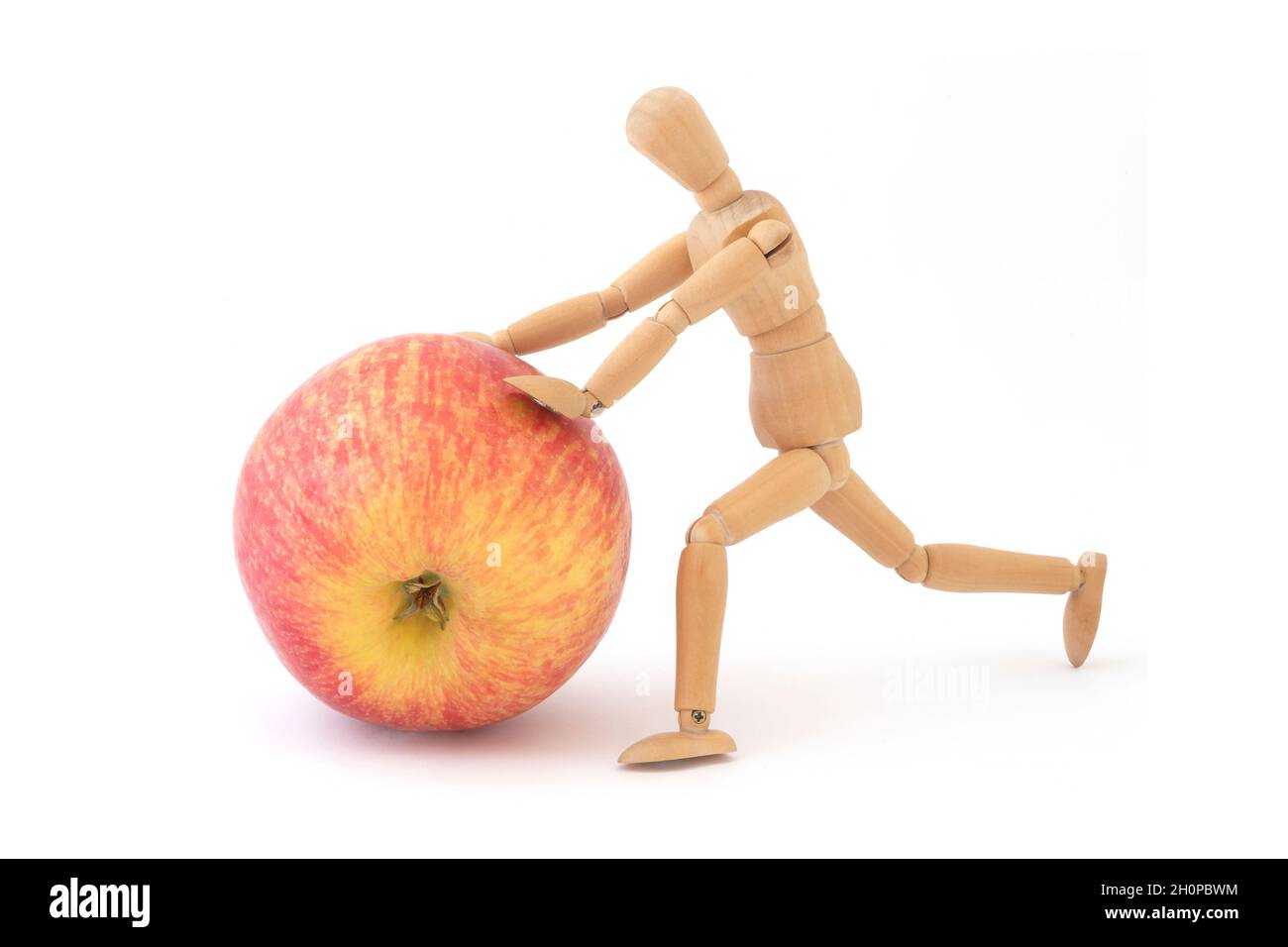 wooden man model rolling red apple isolated on white background Stock ...